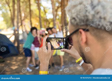 Feche Acima Do Homem Que Fotografa Amigos Com Smartphone Foto De Stock Imagem De Felicidade
