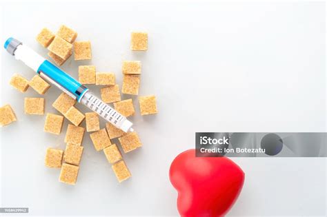 Human Insulin Pen On Top Of Brown Sugar Cane Cubes With Red Heart