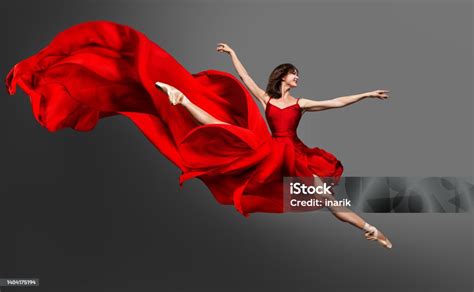 발레리나 댄스 레드 드레스 점프 스플릿의 발레 댄서 발레리나 신발을 신고 실크 가운을 입고 춤을 추는 여성 회색 스튜디오 배경