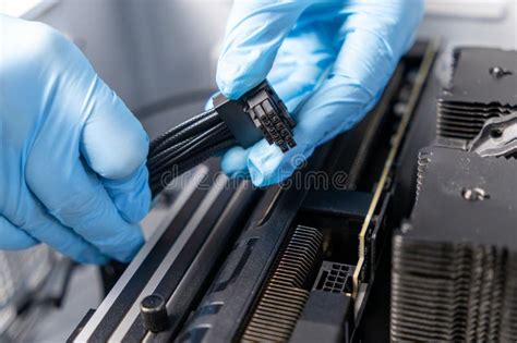 Technician Wearing Blue Gloves Connecting Black Power Cable To Graphics Card Inside High