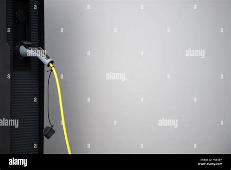 A Charging Cable For An Electric Vehicle Is Connected At A Charging Station E Station In Front