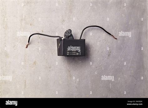 A Broken Capacitor On A Grey Floor Stock Photo Alamy