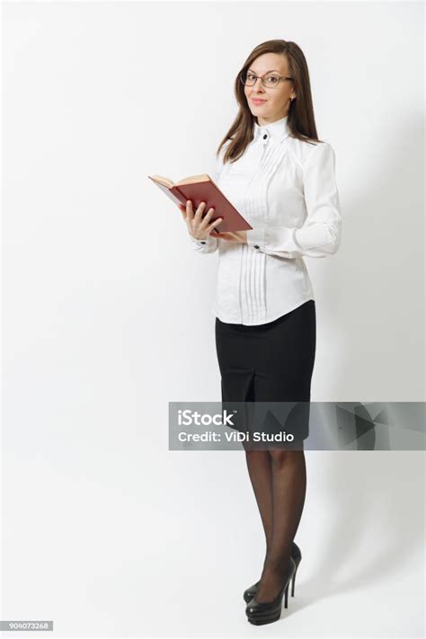 아름 다운 유럽 젊은 웃는 갈색 머리 여자 흰 셔츠 검은 치마 흰색 배경에 고립 된 빨간 책과 안경의 전체 길이입니다 관리자