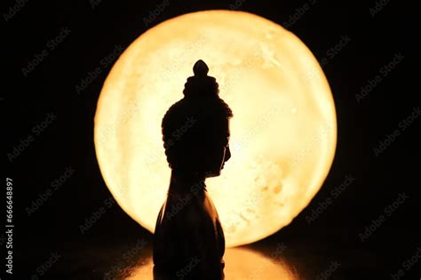 Gautam Buddha Silhouette In Front Of Moon Background In The Dark Creating A Serene Scene Stock