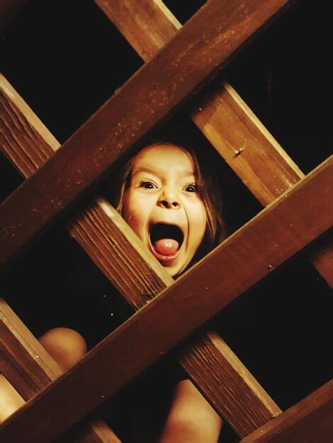 Premium Photo Portrait Of Cute Girl Seen Through Wooden Railing