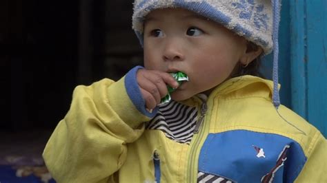 A Small Nepalese Girl Eats Candy Stock Footage Videohive