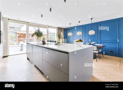 Modern Counters With Flowers In Vase And Fruits In Bowl Located Against