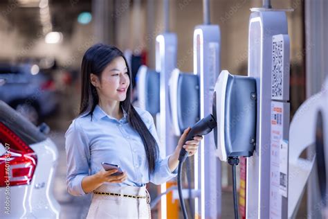 Babe Asian Woman Holding The CCS EV Charging Connector At EV Charging Station In Department