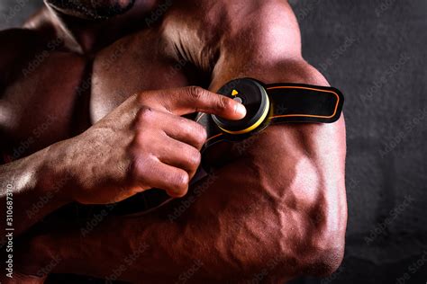 Bodybuilder Male African Uses An Electronic Simulator To Stimulate The