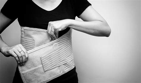 허리 통증과 척추 지원을 위한 허리 지지 벨트를 착용한 검은 색 티셔츠를 입은 여성 흑백 톤 의료 개념 T 셔츠에 대한 스톡 사진 및 기타 이미지 Istock