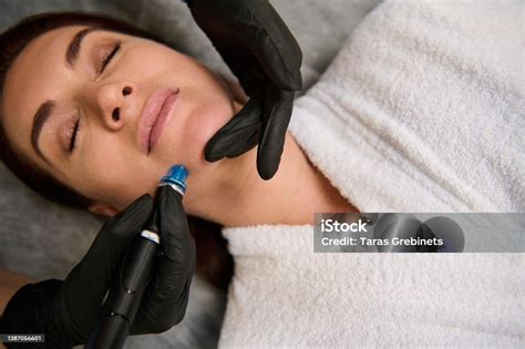 화장품 뷰티 스파 클리닉에서 얼굴 하이드로 미세 피부 마모 박리 치료를 받고 매력적인 중년 여성의 클로즈업 히드라 진공 청소기 각질 제거 회춘 및 수소화 2명에 대한 스톡