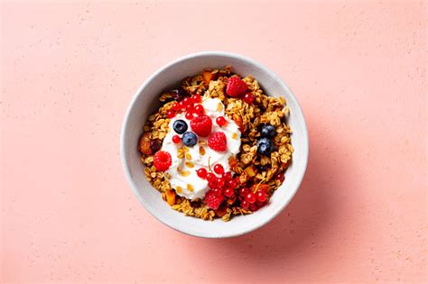 건강한 아침 식사 그래놀라 요구르트와 신선한 베리를 곁들인 뮤즐리 분홍색 배경입니다 평면도 그래놀라에 대한 스톡 사진 및 기타 이미지 Istock