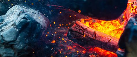 연기가 자욱한 통나무는 생생한 불을 가까이에서 태웠다 캠프 파이어의 불꽃과 대기 배경 복사 공간이있는 내부에서 모닥불의 상상할 수없는 상세한 이미지 연기와 빛나는 불씨의