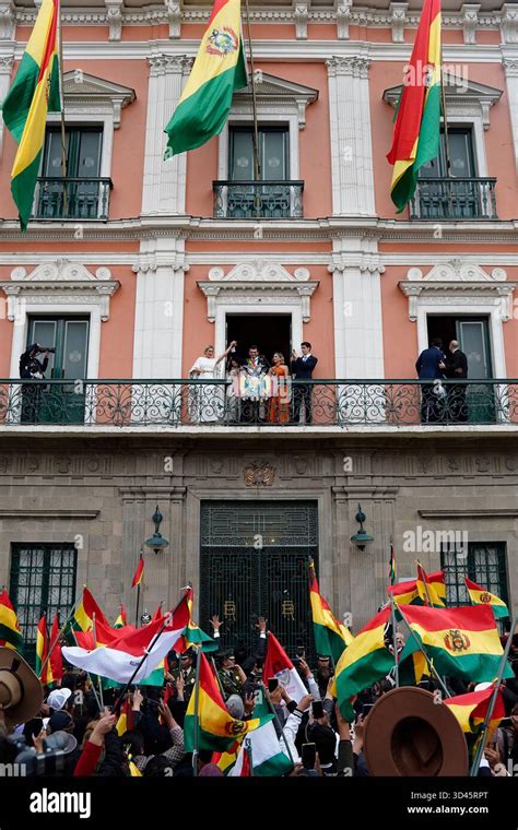 Supporters Of President Rodrigo Paz Hold Bolivian Flags As He Stands On