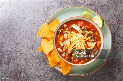 콩 옥수수 토마토와 함께 향기로운 국물로 조리 한 치킨 타코 수프는 라임과 또띠아 칩을 접시에 클로즈업합니다 수평 평면도 체더 치즈에 대한 스톡 사진 및 기타 이미지