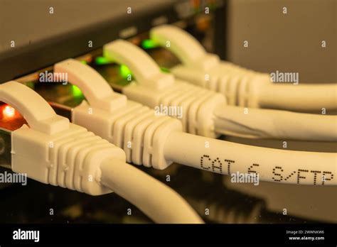 Close Up On Network Switch With Several Lights On And Network Cables