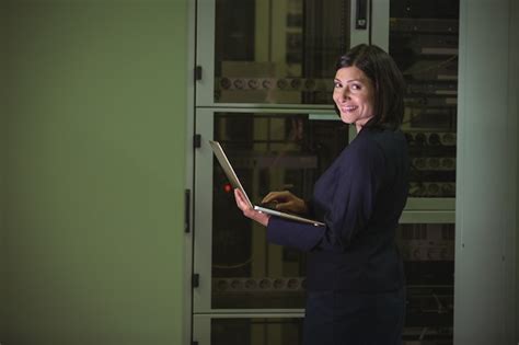 Premium Photo Technician Using Laptop While Analyzing Server