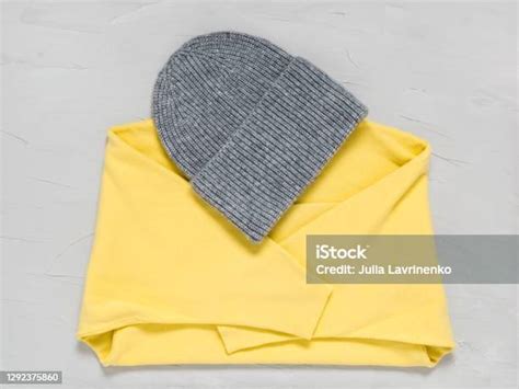 니트 그레이 모자와 스웨터는 2021년 유행의 컬러로 옐로우와 얼티밋 그레이를 조명합니다 유행 따뜻한 가을 이나 겨울 옷과 액세서리 콘크리트 배경에 울 질감 0명에 대한