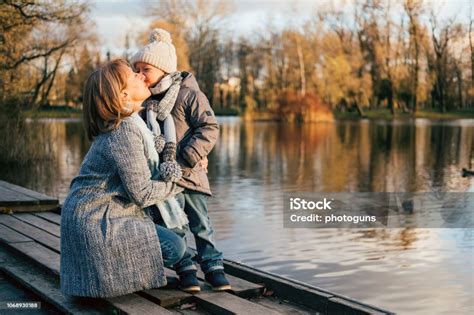엄마와 아이가을 공원에서 포옹 호수 근처 재미 휴식 인생을 즐기는 엄마와 함께 행복 한 아들 어머니의 날 가족 공원에 깨어입니다