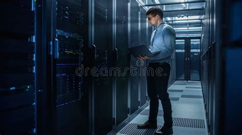 In Data Center It Engineer Stands Before Working Server Rack Doing Routine Maintenance Check And