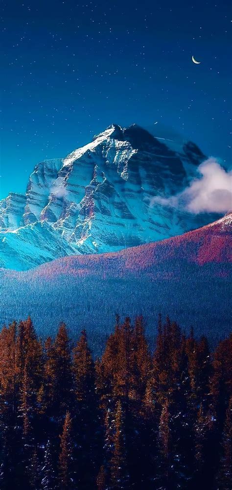the mountain is covered in snow and has trees on both sides, under a ...