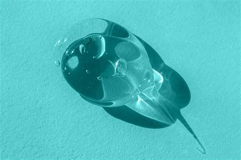 거품이 묻은 알로에 베라 클렌저 로션 스미어 스타일링 젤 스와치 샴푸 드롭 압착 된 화장품 젤 얼룩이 푸른 그림자 배경에 얼룩집니다 매크로 투명한 물방울 클로즈업 메이크업