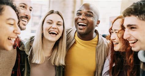 도시 거리에서 함께 즐거운 시간을 보내는 다인종 친구들 밖에서 껴안고 웃는 밀레니얼 세대 사람들 밖에서 어울리는 것을 즐기는 남자와 여자와의 우정 개념 사진