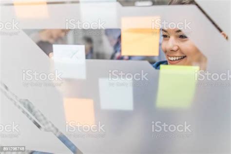 크리에이 티브 여 자가 사무실에 접착 메모에 비즈니스 전략을 쓰고 웃 고 계획에 대한 스톡 사진 및 기타 이미지 계획