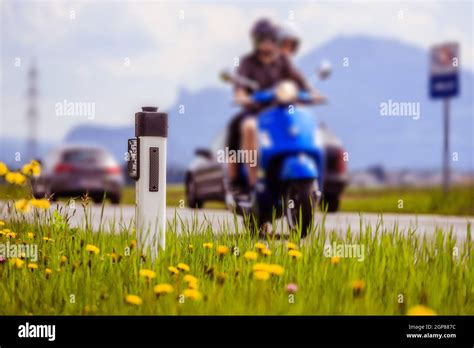 Reflector Post And A Couple On A Motor Bike At An Idyllic Asphalted