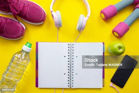 녹색 사과와 물 병 분홍색 운동화와 아령 노란색 배경에 휴대 전화가있는 펜과 헤드폰이있는 노트북 0명에 대한 스톡 사진 및 기타 이미지 Istock