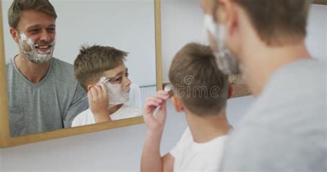 Caucasian Man And His Son In The Bathroom With Shaving Foam On Their