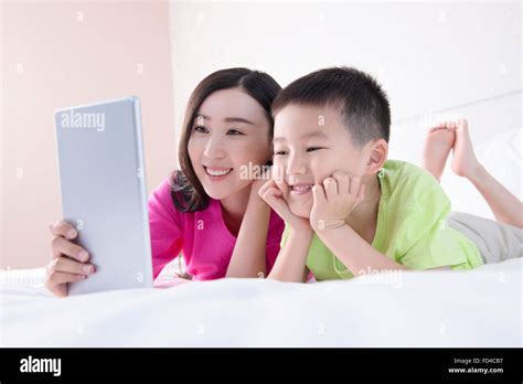 Mother And Son Using Digital Tablet In Bed Stock Photo Alamy
