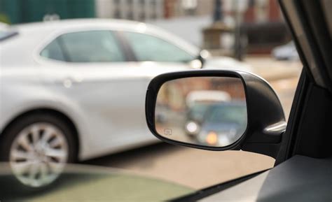 Cars Rearview Mirror Reflecting A Scenic Road Behind The Mirror