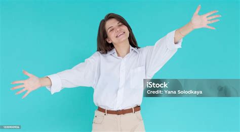 파스텔 블루 월 배경 스튜디오 초상화에 고립 포즈 흰색 셔츠에 미소 젊은 갈색 머리 여자 소녀 사람들 라이프 스타일 개념 복사 공간을 모의합니다 뻗은 손으로 서 광대한에