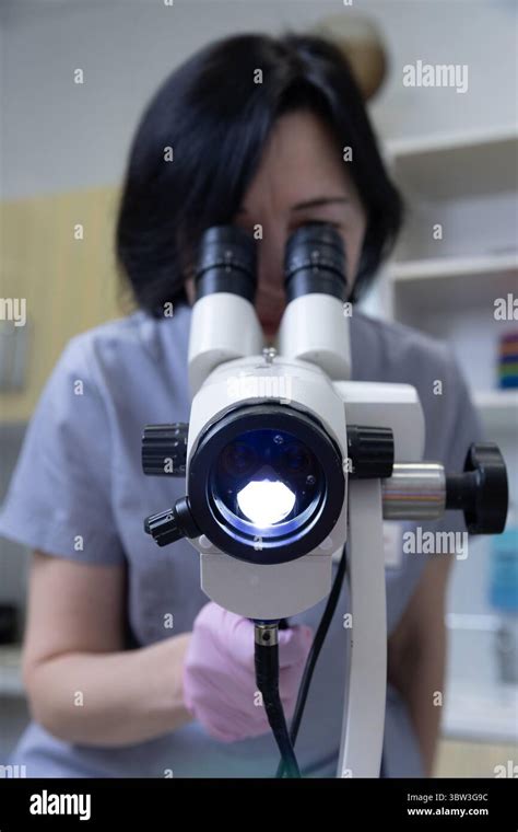 Dedicated Professional Analyzing Samples Under Microscope In A Modern