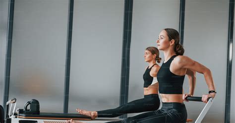 손의 힘 스포티한 옷을 입고 날씬한 몸매를 가진 두 명의 여성이 실내에서 함께 피트니스 요가의 날을 보냅니다 사진