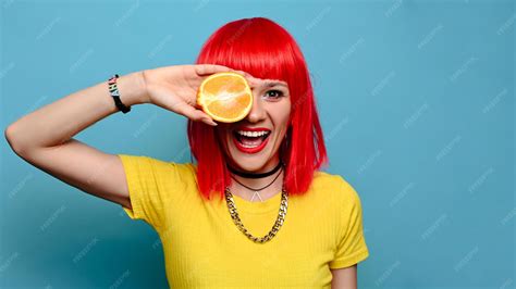 Premium Photo A Young Beautiful Funny Model With A Slice Of Orange Near Her Eyes In The