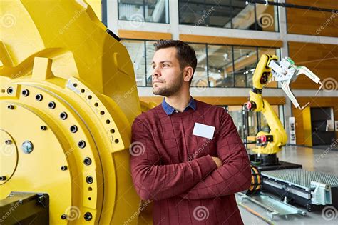 Engineer Supervising Industrial Robot With Gripper Arm In Modern