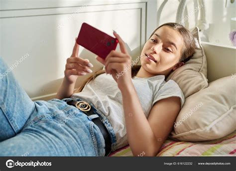 Девочка Подросток Лежащая Постели Смартфоном Досуга Подросток Отправляющая Смс Телефону стоковое