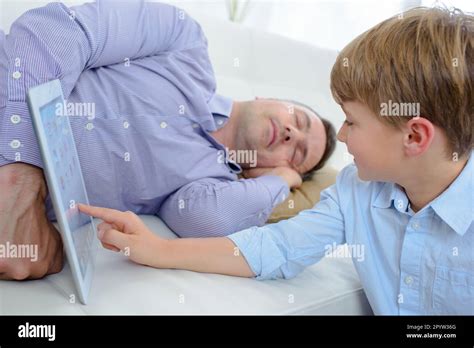 Father Sleeping Son Using His Touchpad Stock Photo Alamy
