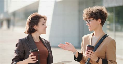 태블릿을 든 두 명의 젊은 여성 동료가 비즈니스 센터에 대해 음료를 마시면서 도시 환경에서 작업 지점에 대해 논의합니다 사진 Unsplash의 매니저 이미지