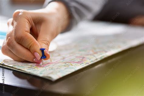 Female Hand Holding Pushpin Showing The Location Of A Destination Point On A Map Travel