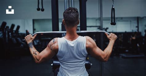 회색 탱크탑과 검은색 반바지를 입은 남자가 검은색 바벨을 들고 있다 사진 Unsplash의 무료 영광은 체육관을 얻는다 이미지