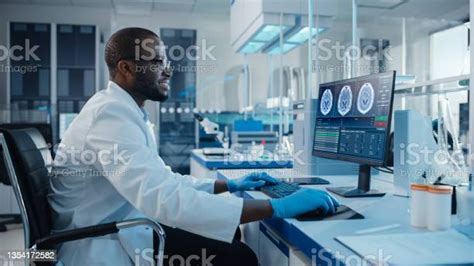 ห้องปฏิบัติการทางการแพทย์สมัยใหม่ นักวิทยาศาสตร์ชายพิมพ์บนแป้นพิมพ์ทํางานบนคอมพิวเตอร ภาพสต็อก