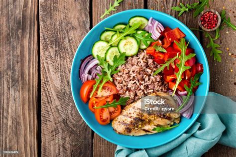 구운 치킨 가슴살 튀긴 치킨 필 레와 토마토 오이 후추 양상추와 Arugula 잎의 신선한 야채 샐러드 샐러드와 치킨 고기 건강 한 음식 평평한 누워 평면도 나무 배경