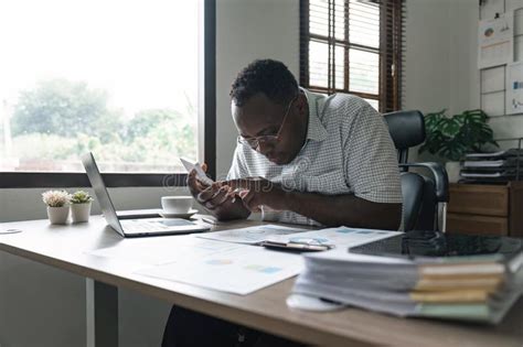 African American Man Calculating Using Machine Managing Household Finances At Home Focused