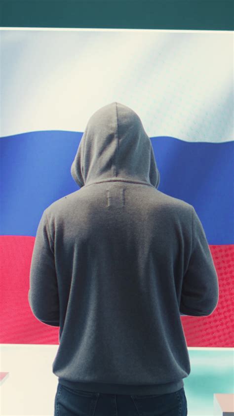 Vertical A Russian Hacker Working In A Governmental Hacking Room With The Russian Flag On Big