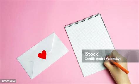 여성 손 사랑 편지를 쓰고입니다 발렌타인 데이 개념입니다 인사말 발렌타인 카드입니다 사랑의 선언입니다 결혼식 초대장입니다 레드 심장입니다 핑크 배경입니다 위에서 볼 수