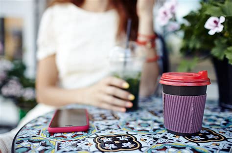 여성 손은 도시 카페에서 모히토와 플라스틱 컵을 들고 테이블에 커피와 스마트 폰의 종이 컵 흐릿한 이미지 커피에 집중 각얼음에