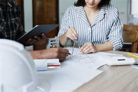 工程师正在咨询团队,为客户设计建筑结构,并提供蓝图和建筑模型,以便在办公室工作高清摄影大图 千库网 工程师正在咨询团队,为客户设计建筑结构,并提供蓝图和建筑模型,以便在办公室工作高清摄影大图 千库网